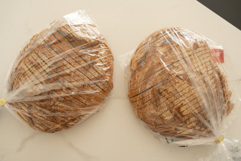 Sliced Bread Loaves Wrapped in Plastic on a Table Stock Photo - Image ...