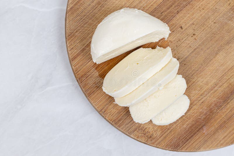 Sliced Mozarella Cheese on the Round Wooden Board Stock Photo - Image ...