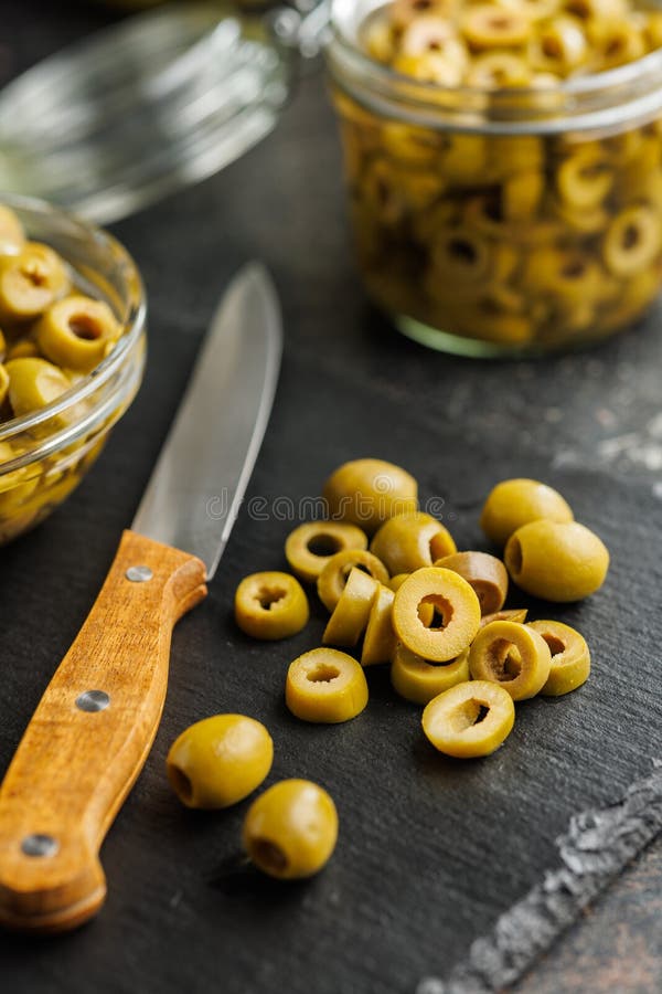 Sliced Pickled Green Olives in Brine on Cutting Board on Black Table ...