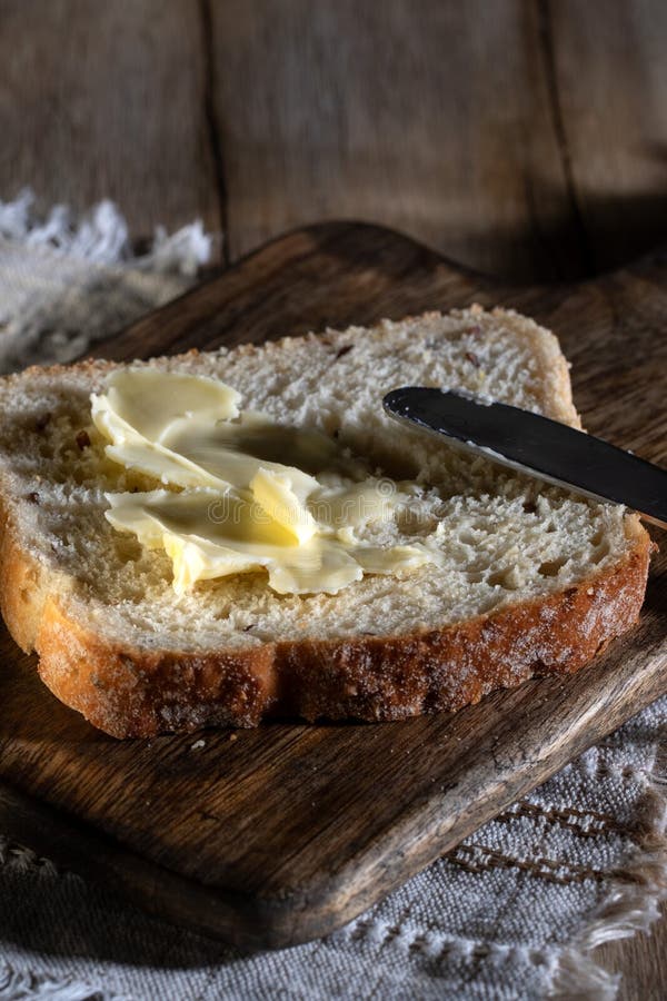 Sliced ??piece of White Bread with Butter Spread on a Rustic Table ...