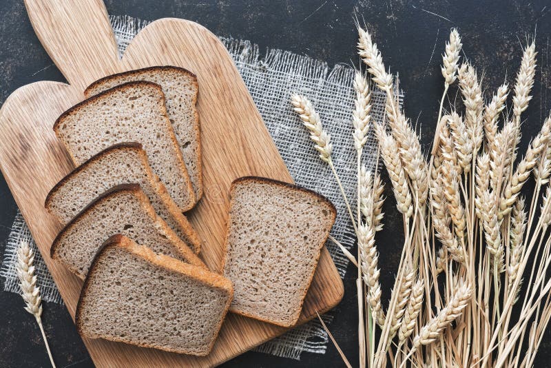 Sliced Rye Bread and Spikes of Rye on a Dark Background. Flat Lay ...