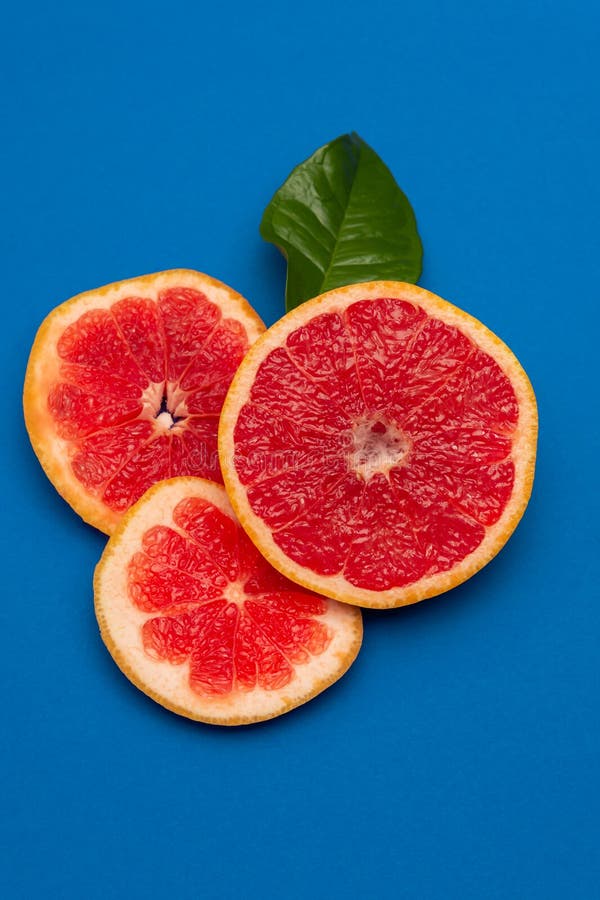 Sliced Sides of a Grapefruit, Three Pieces with a Green Leaf, Red Pulp ...