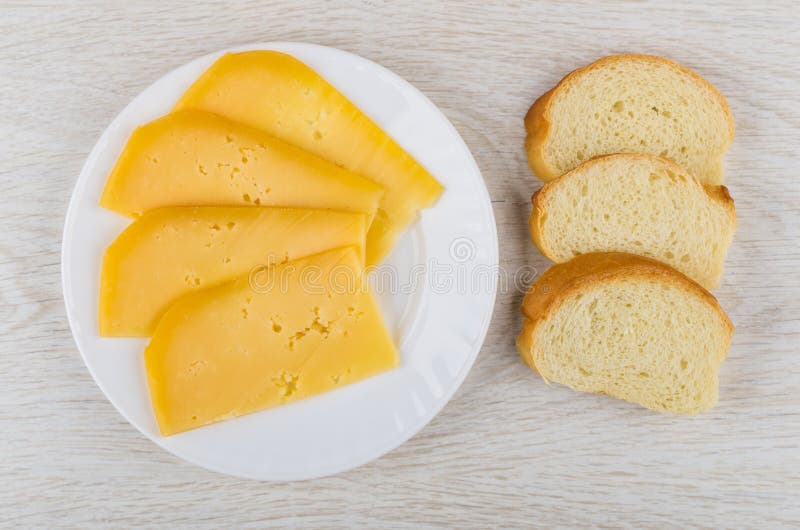 Slices of Cheese in Plate, Pieces of Bread on Table Stock Photo - Image ...