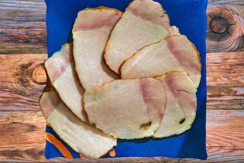 Slices of Ham on a Square Blue Dish on a Wooden Table Background Stock ...