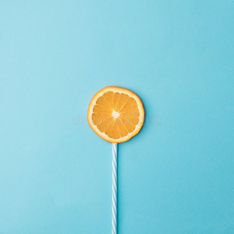 Slices of Orange on a Plastic Stick. Blue Background. Copy Space Stock ...