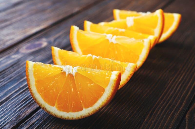 Slices of Orange Wooden Bowl on Wooden Table. Top View. Toned Stock ...
