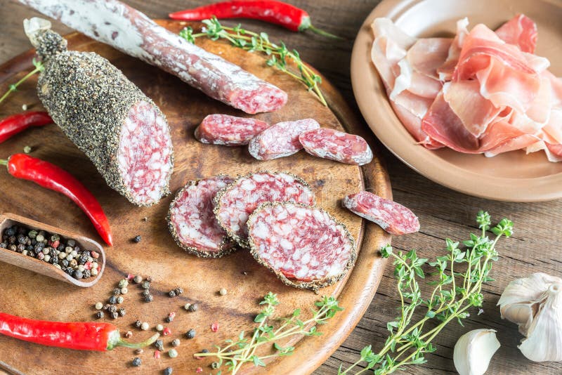 Slices of Saucisson, Jamon and Salami on the Wooden Board Stock Photo ...