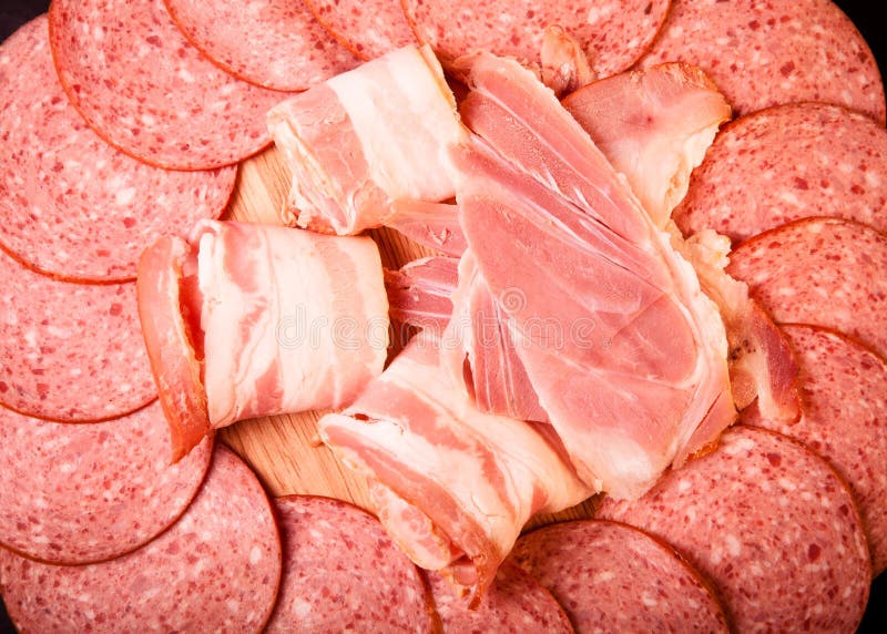 Slices of Sausage and Bacon on a Round Cutting Board. Toned Stock Photo ...