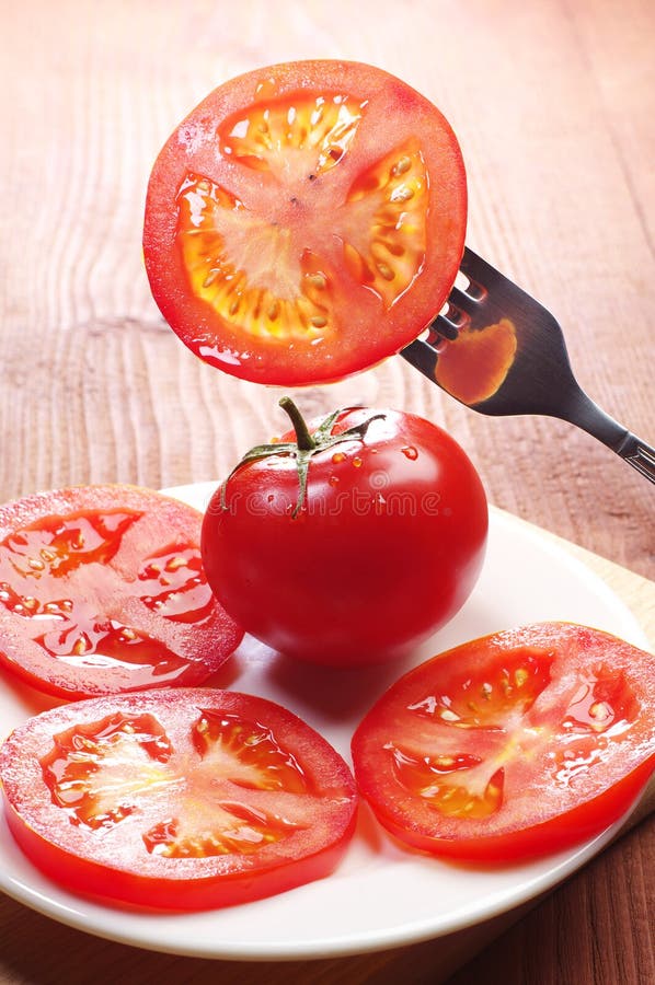 Slices Tomato on a Fork and in a Plate Stock Photo - Image of sliced ...