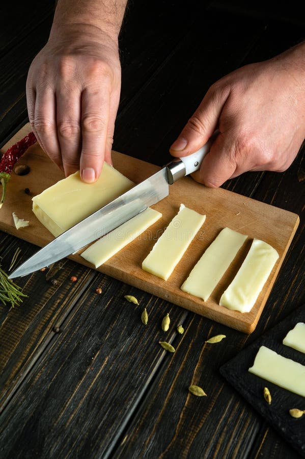 Slicing Cheese for Table Setting for Lunch in a Restaurant. Knife in ...