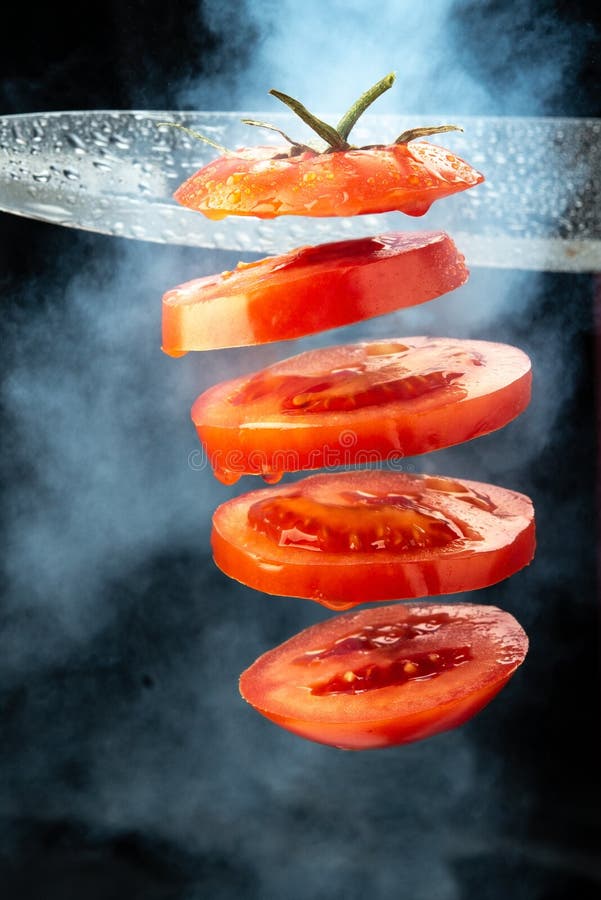 Slicing a Tomato on a Steam Background Stock Photo - Image of dark ...