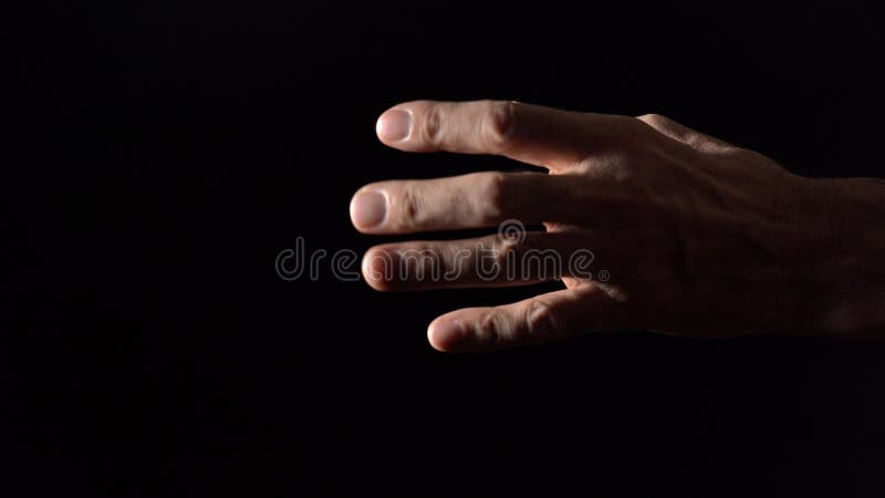 Slim Male Hand Reaching Out To Light on Black Background Stock Video ...