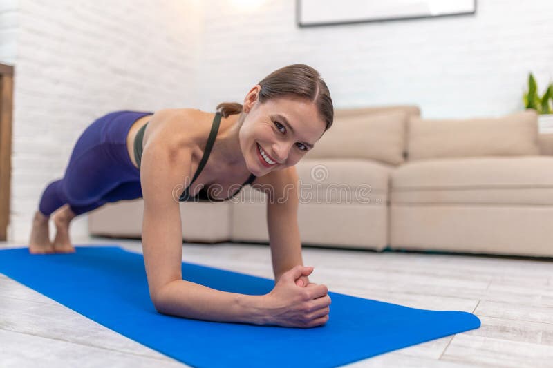 Slim Young Woman Standing in Plank on a Blue Mat Stock Photo - Image of ...
