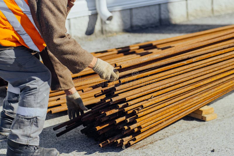Slinger Stacks Thin Metal Pipes in Stack on Construction Site. Close-up ...