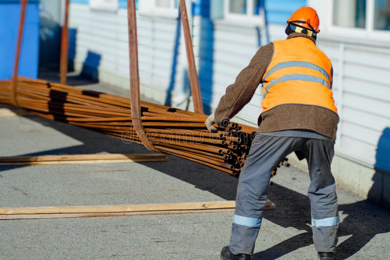 Slinger Stacks Thin Metal Pipes in Stack on Construction Site. Close-up ...