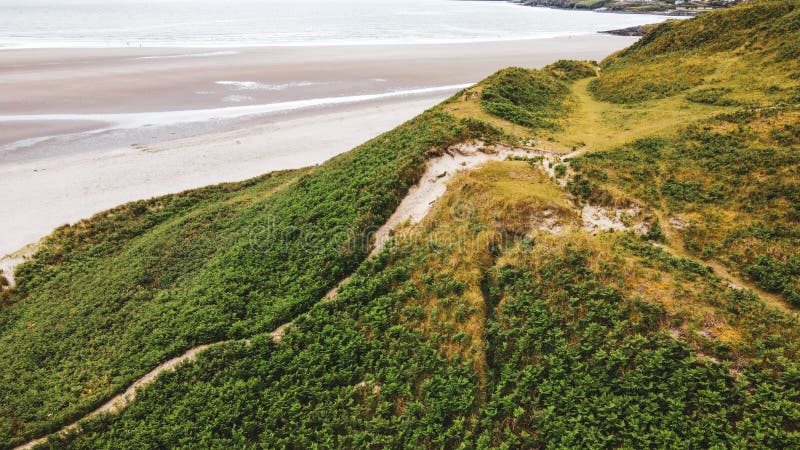 The Slope of a High Hill on a Sandy Seashore. Green Grass Covered ...