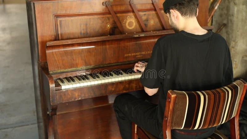 Slow Motion View of Young Man from Behind Sitting in Front of Wooden ...