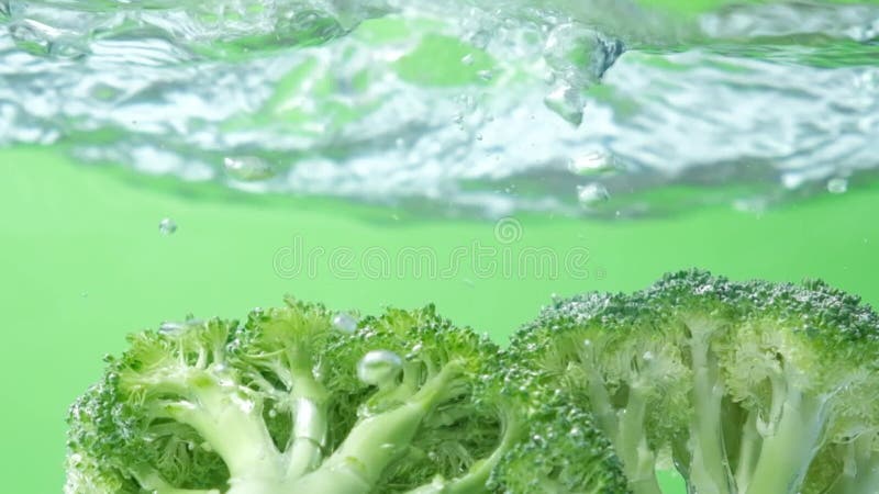 Slow Motion Fall of Green Broccoli into Clear Water with Splash Effect ...