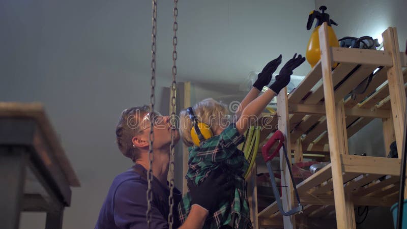 Slow Motion, Man Helps Boy To Take Tool from the Shelf Stock Photo ...