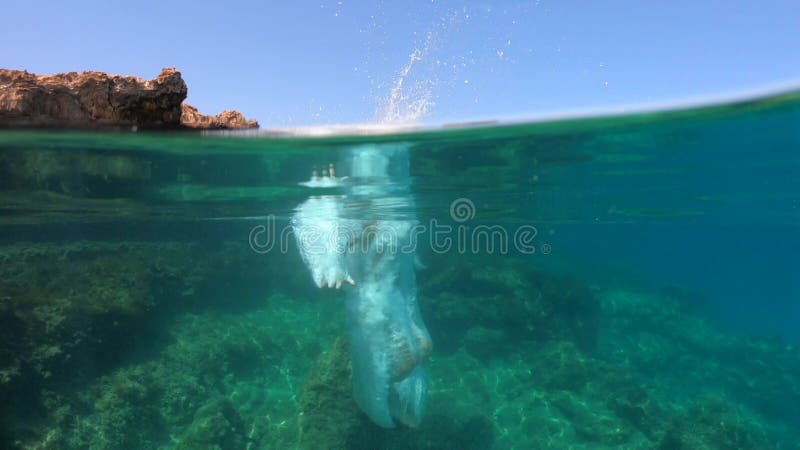 Slow Motion of Man Jumping Off Cliff into the Sea. Underwater Stock ...