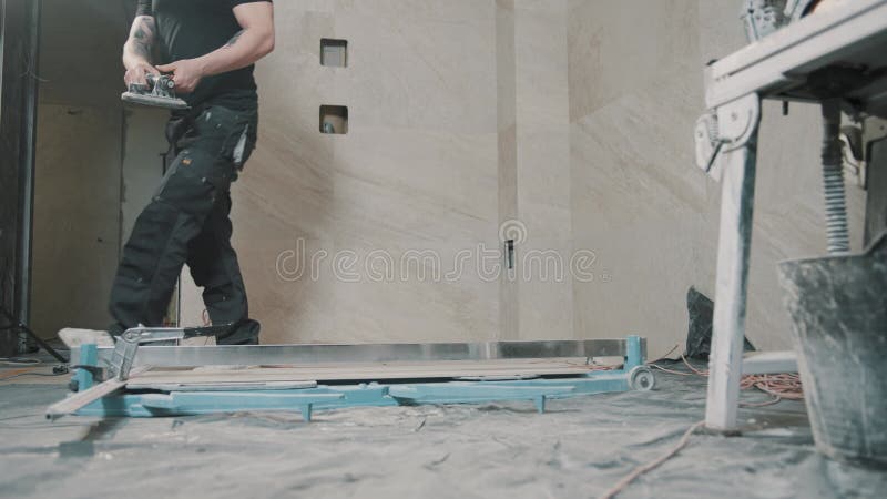 Slow Motion of a Man Lifting a Large Tile in a Construction Site during ...