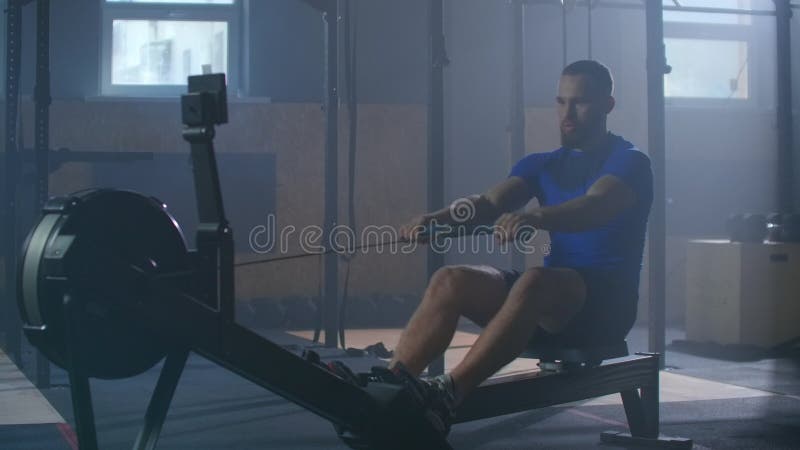 Slow Motion Men Training Rowing in Gym with Exercises Machines and Pull ...