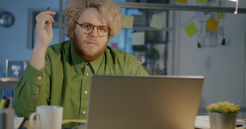 Slow Motion Portrait of Blond Young Man Sitting at Computer Desk in ...