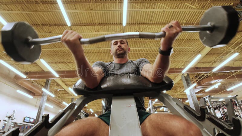 Slow Motion Shot. Modern Gym, a Guy Sitting Down on the Training ...