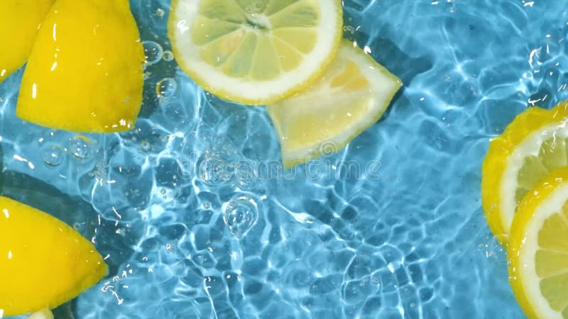 Slow Motion of a Slices of Fresh Lemons Falling into Water Top View ...