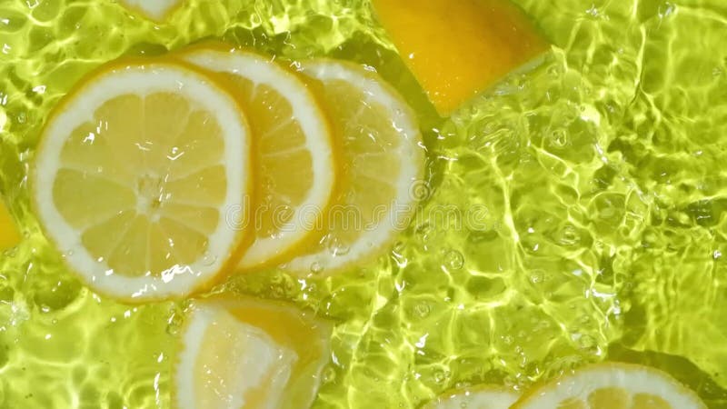 Slow Motion of a Slices of Fresh Lemons Falling into Water Top View ...