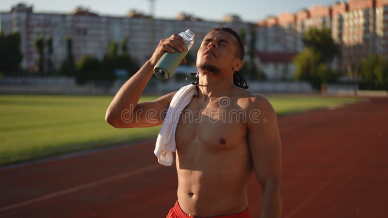Slow Motion. a Tired Runner with Dreadlocks Pours Water from a Plastic ...
