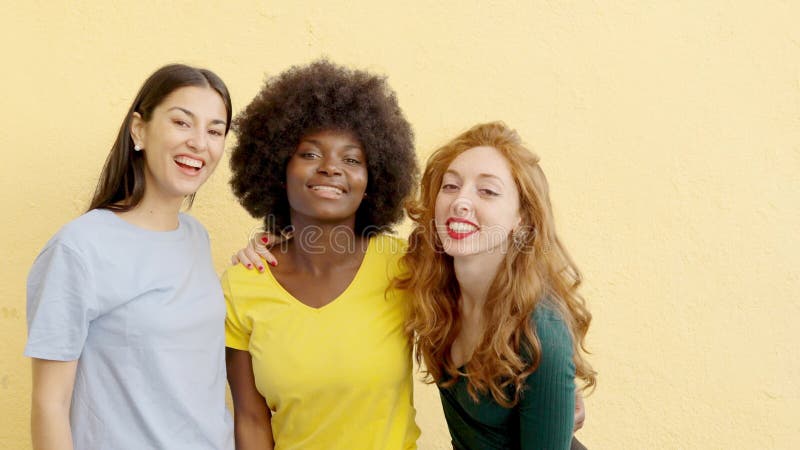 Three Multicultural Smiling Young Women Friends Embracing Looking at ...
