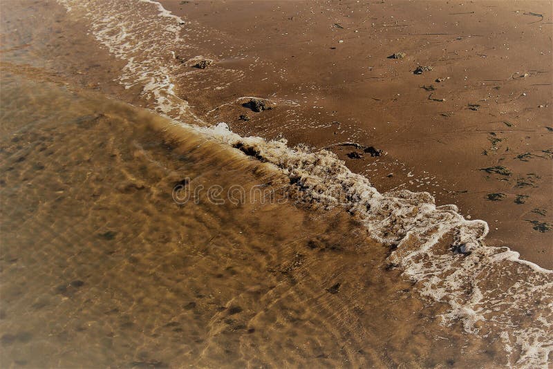 Waves Splash a Beach with White Bubbles -Zeke Color Stock Image - Image ...