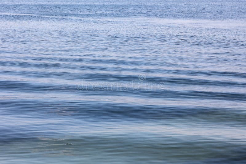 Slowly Moving Littles Waves on Water with Reflections of the Blue Sky ...