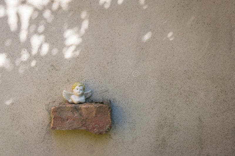Small Angel Sculpture Placed on Brick on Wall Stock Image - Image of ...