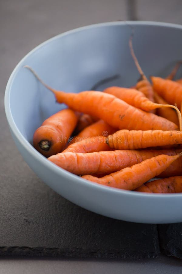 Small Baby Carrots in Soup Plates Stock Photo - Image of board ...