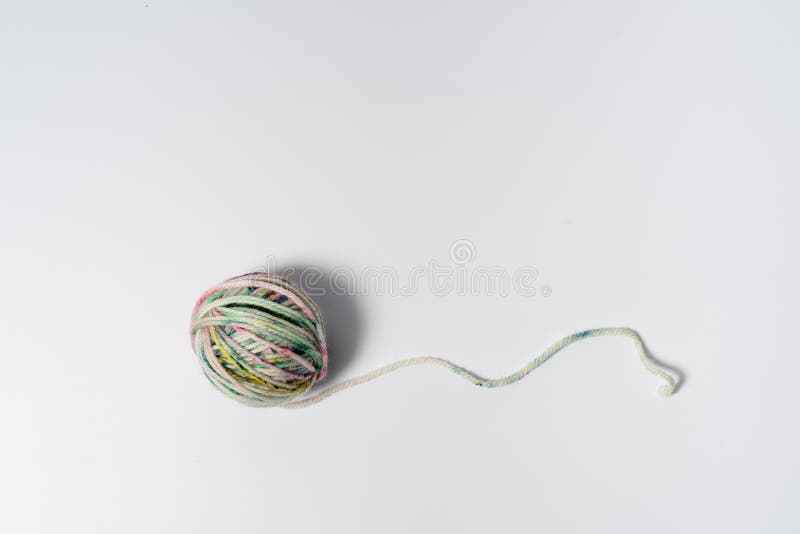 Small Ball of Light Multicolored Yarn with a Loose String on White ...