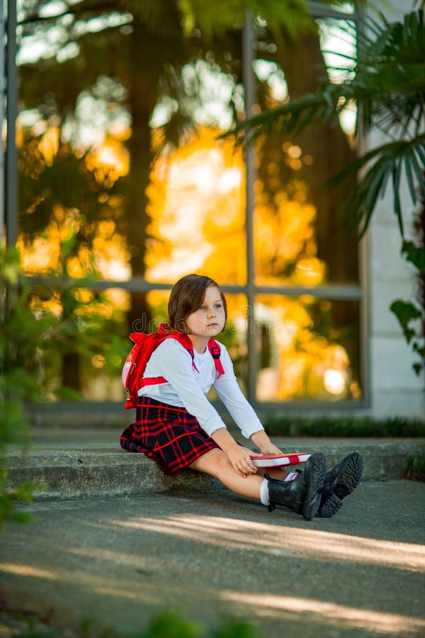 A Small, Beautiful Girl, Sitting on the Steps of a School, in a School ...