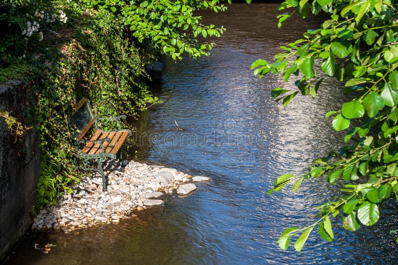 Bench by a small stream stock image. Image of freshness - 120175403