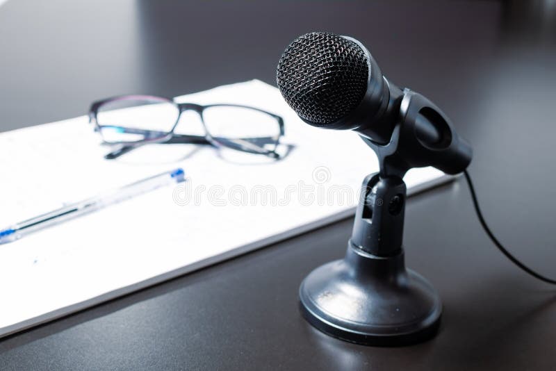 Small Black Desk Microphone with Cable and Low Stand on a Black Table ...