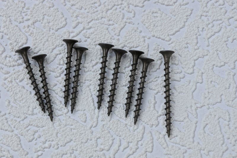 Gray and Black Small Screws in a Pile on a Gray Table Stock Photo ...