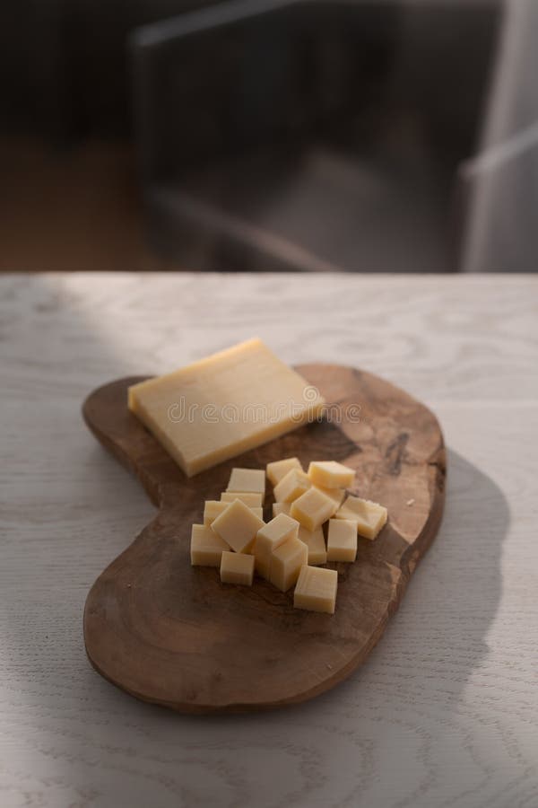 Small Block of Aged Cheese Sliced in Small Pieces on Wood Board Stock ...