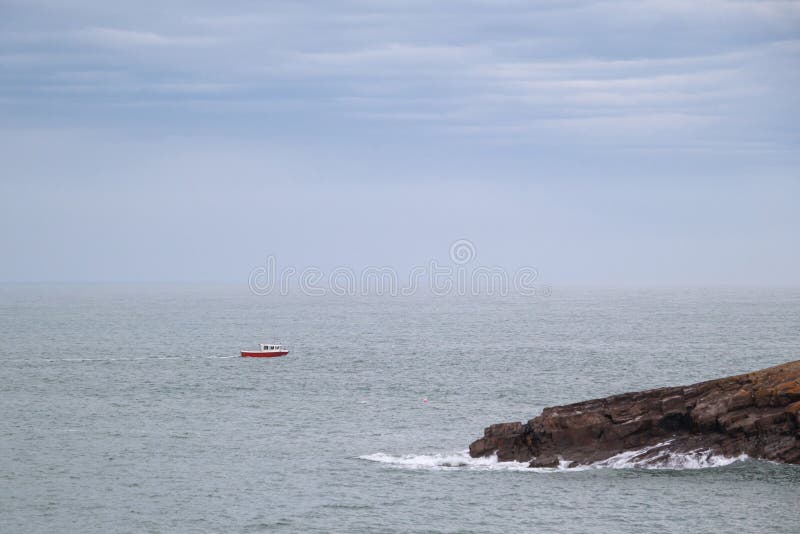 Small Boat in the Misty Sea Near the Rocks on the Shore Stock Image ...