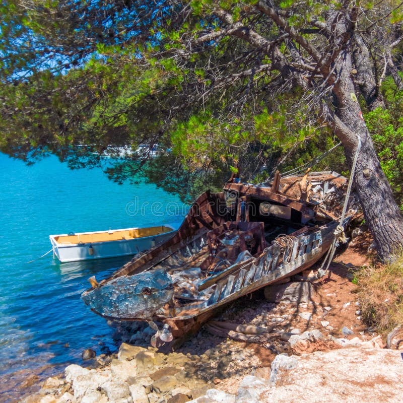 Small Boat Shipwreck on a Rocky Beach Tied To a Tree Stock Image ...