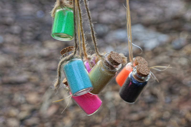 Bottles with Colored Water and Flowers Hanging on a String on Summer ...