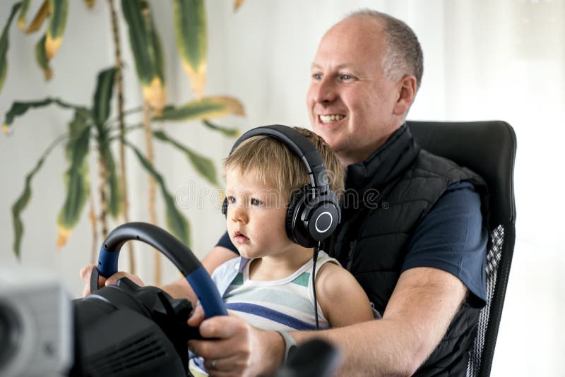 Small Boy Carefully Watching His Dad Playing Racing Car Game on the ...
