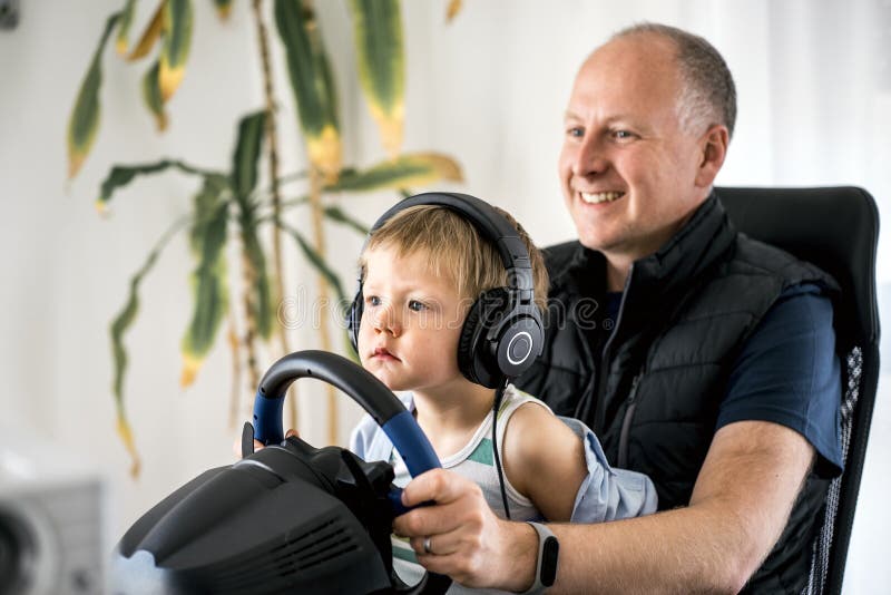 Small Boy Carefully Watching His Dad Playing Racing Car Game on the ...