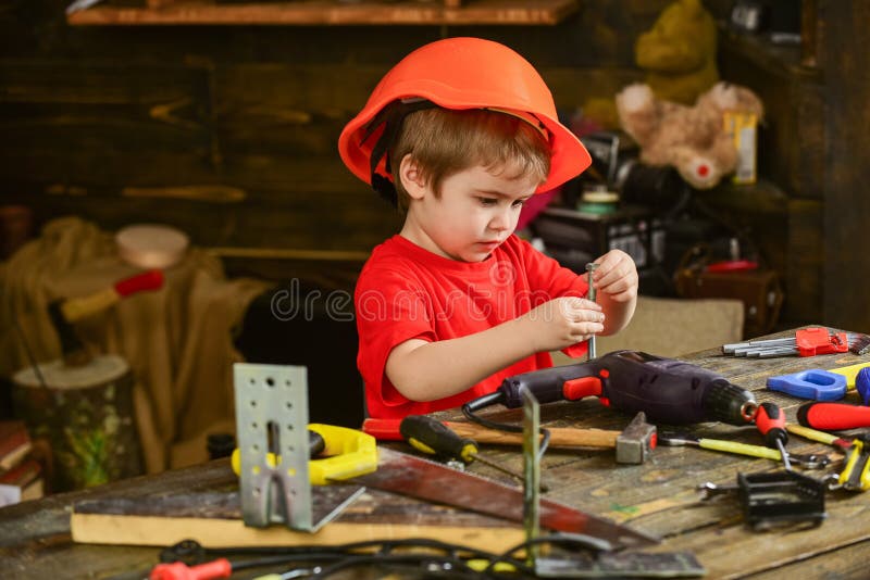 Small Boy Piling Up Big Metal Bolts. Side View Cute Kid Playing with ...