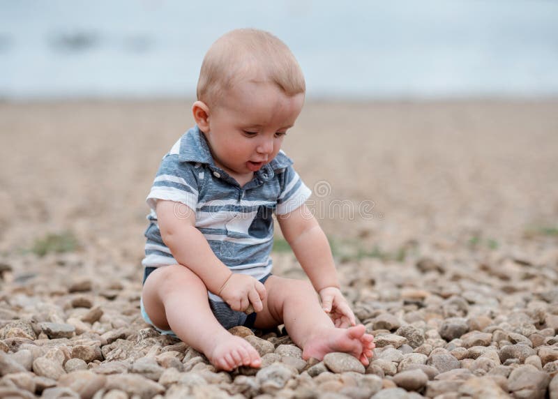 Small Boy Playing with Stones on the Seaside Stock Photo - Image of ...