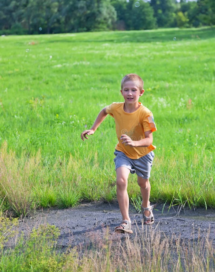 Small Boy Running on Green Meadow Stock Photo - Image of caucasian ...